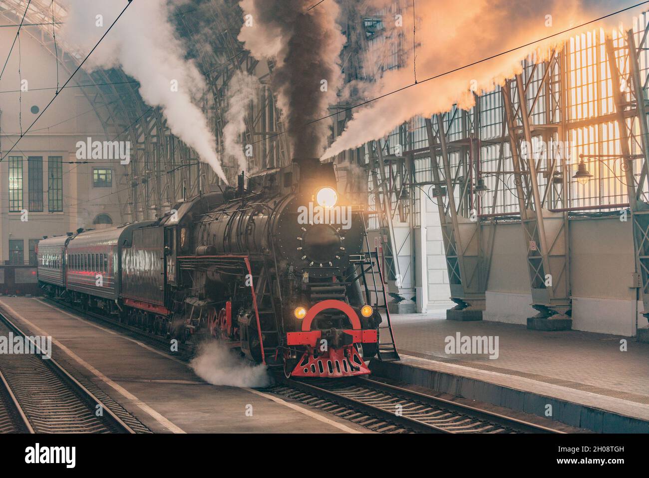 Retro steam train departs from the station at morning time Stock Photo ...