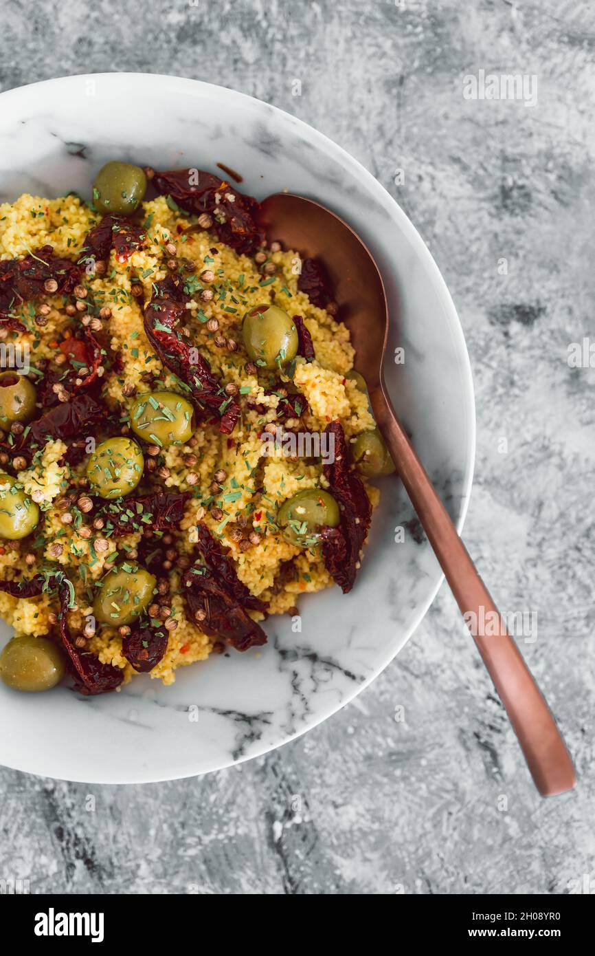 vegan spicy cous cous with sundried tomatoes and olives topped with ...