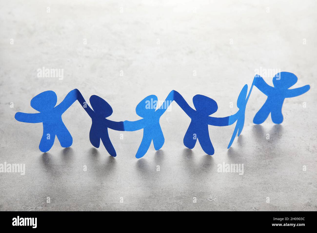 Paper people chain on light background. Helping and supporting concept ...