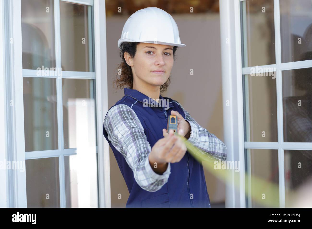 happy beautiful woman builder with tape measure Stock Photo - Alamy