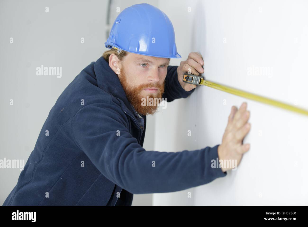 low angle portrait of handsome engineer measuring walls Stock Photo - Alamy