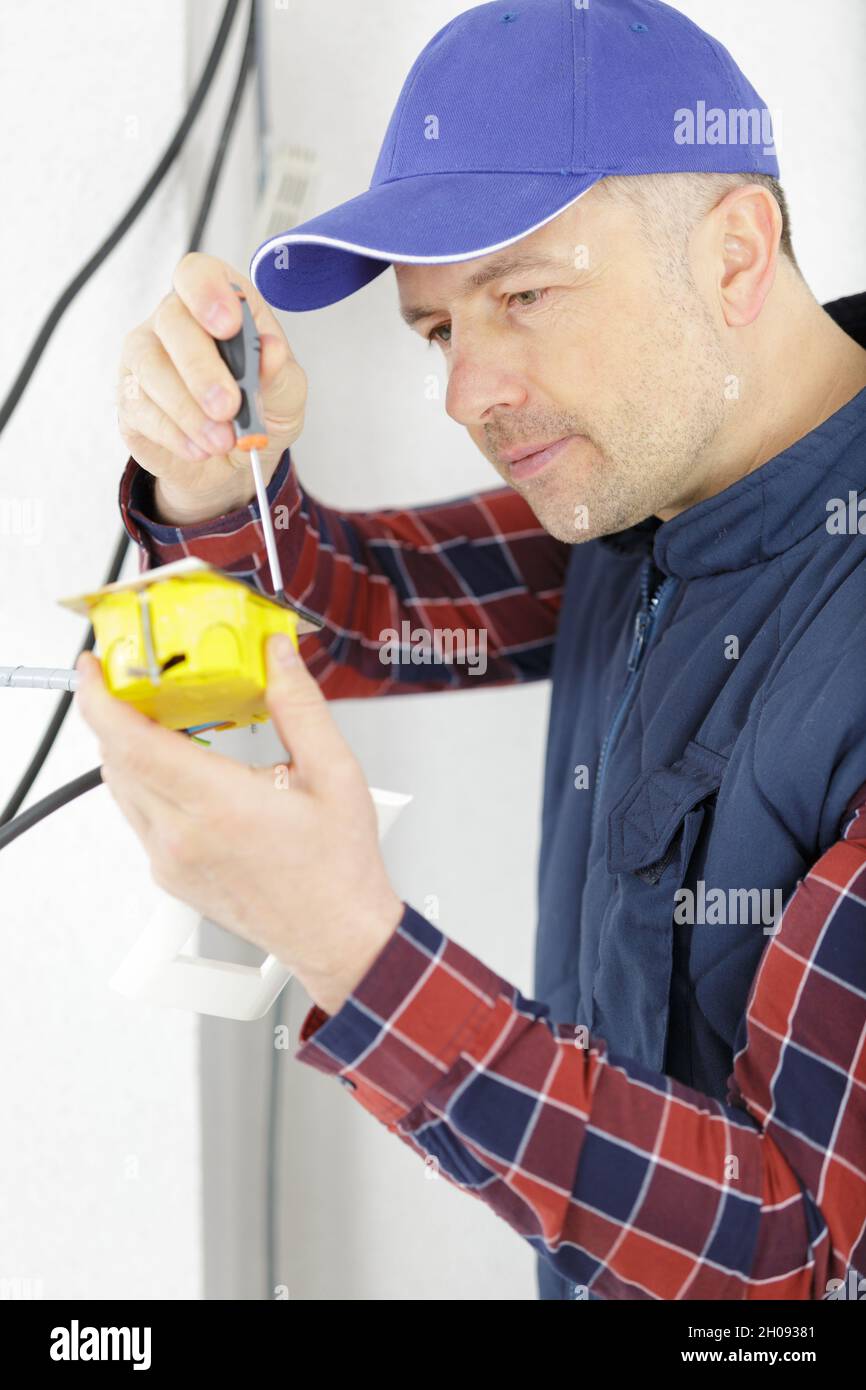 male electrician opening wiring junction box Stock Photo - Alamy