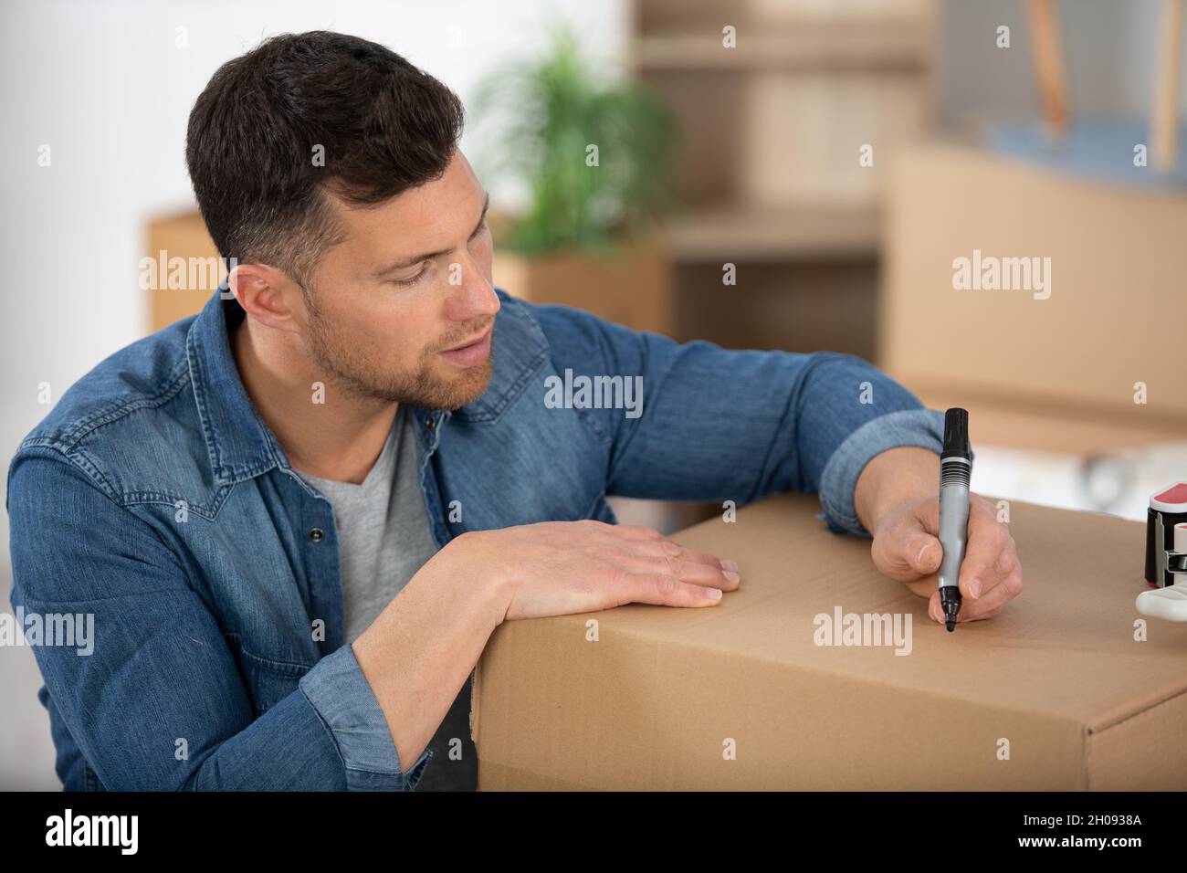 man writing on a parcel box Stock Photo - Alamy