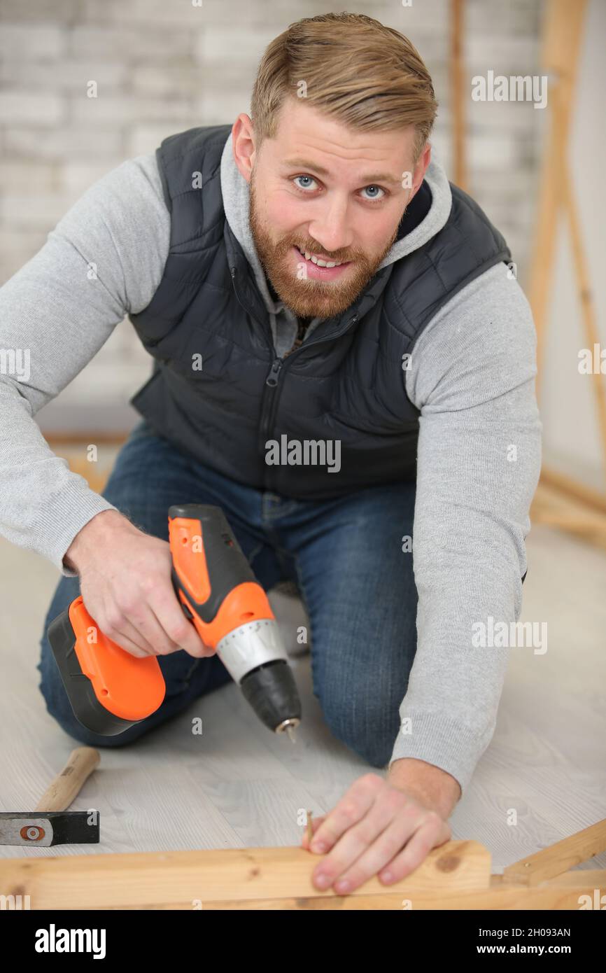 man using battery screwdriver to insert screw into wood Stock Photo - Alamy