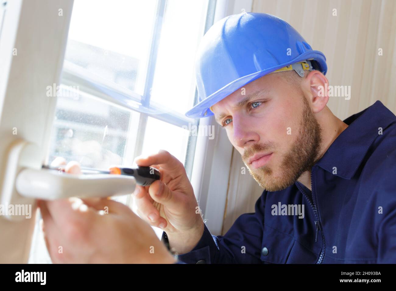 builder tightening a screw with a screwdriver Stock Photo - Alamy