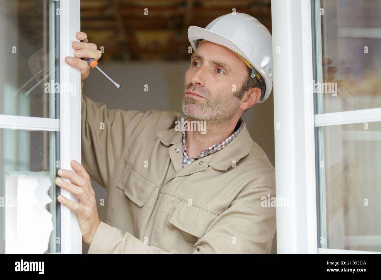 handyman repairing window with screwdriver Stock Photo - Alamy