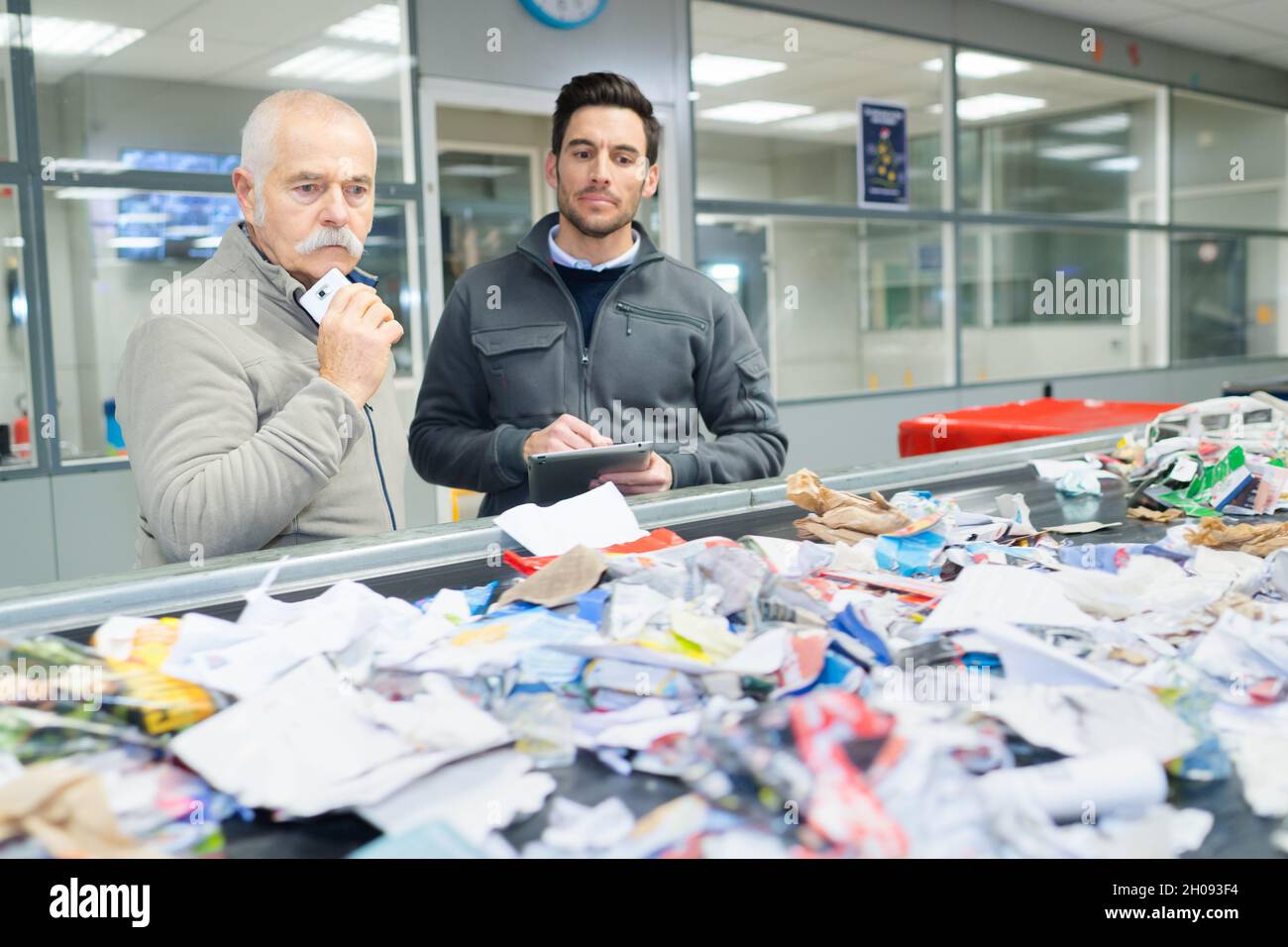 men watching over conveyor in recycling center Stock Photo - Alamy