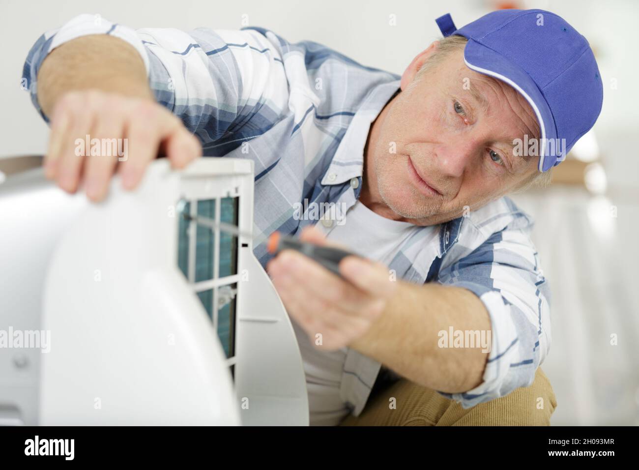 senior man using screwdriver on electrical appliance Stock Photo - Alamy