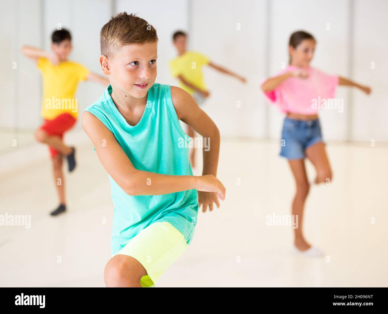 Group of fashionable children learning a modern dance while having ...