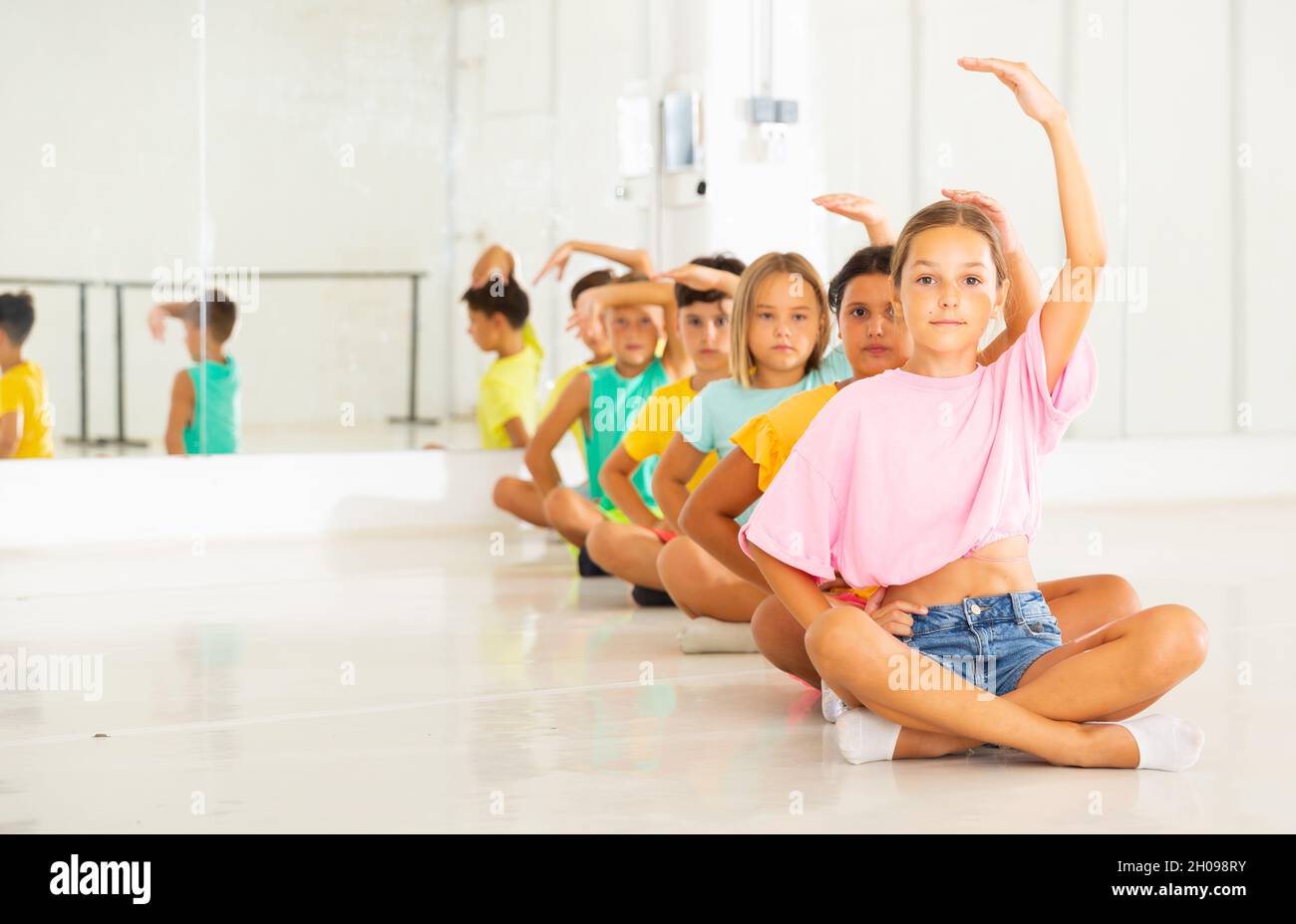 Children sitting and exercising ballet moves in studio Stock Photo - Alamy