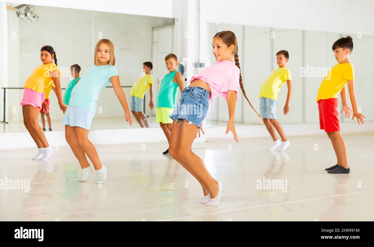 Kids warming up in group dance class, doing stretching exercises before ...