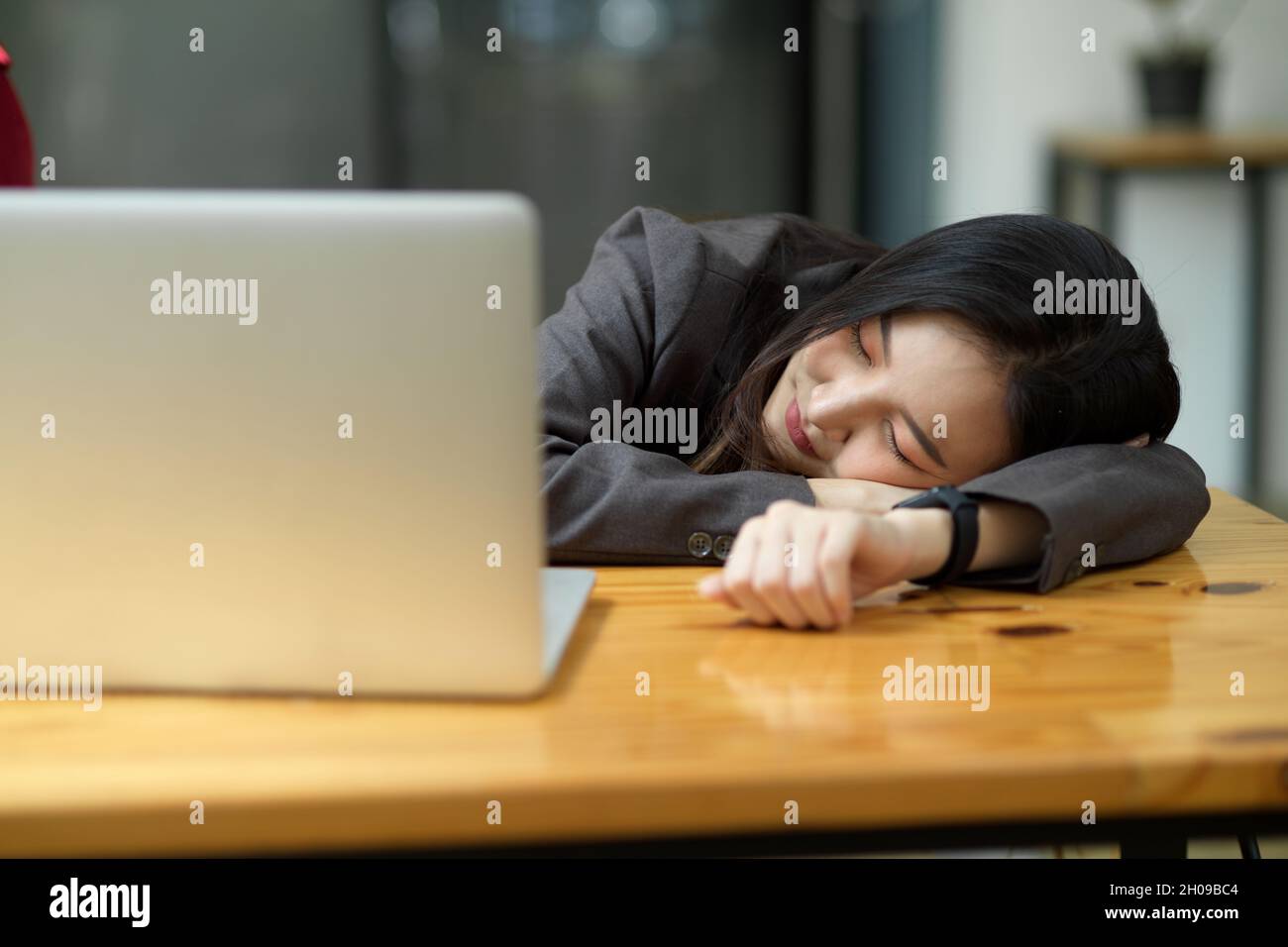 Tired or exhausted young business woman napping on working desk in ...