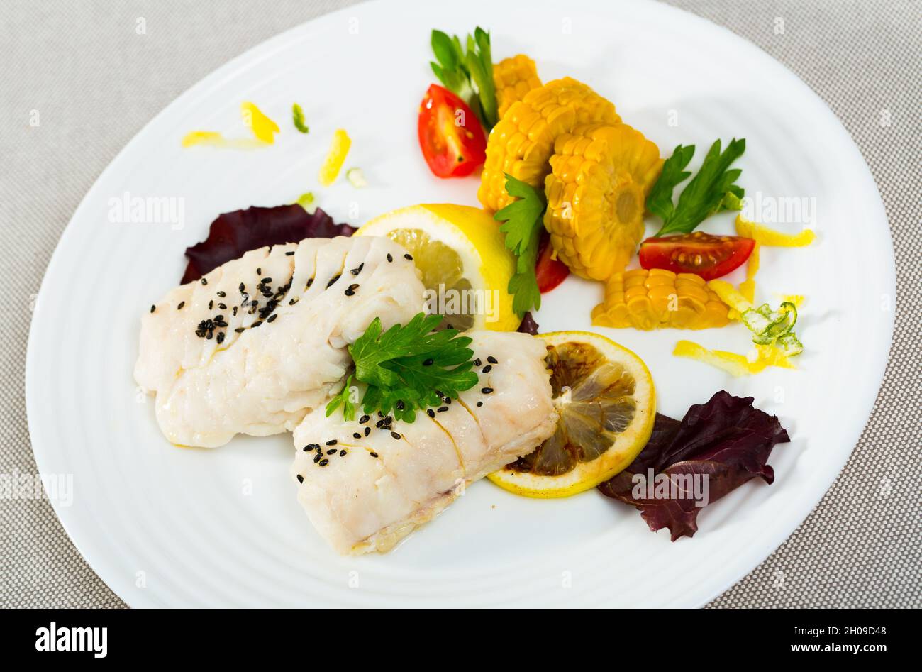 Hake steamed with corn, greens and lemon. Recipe Stock Photo - Alamy