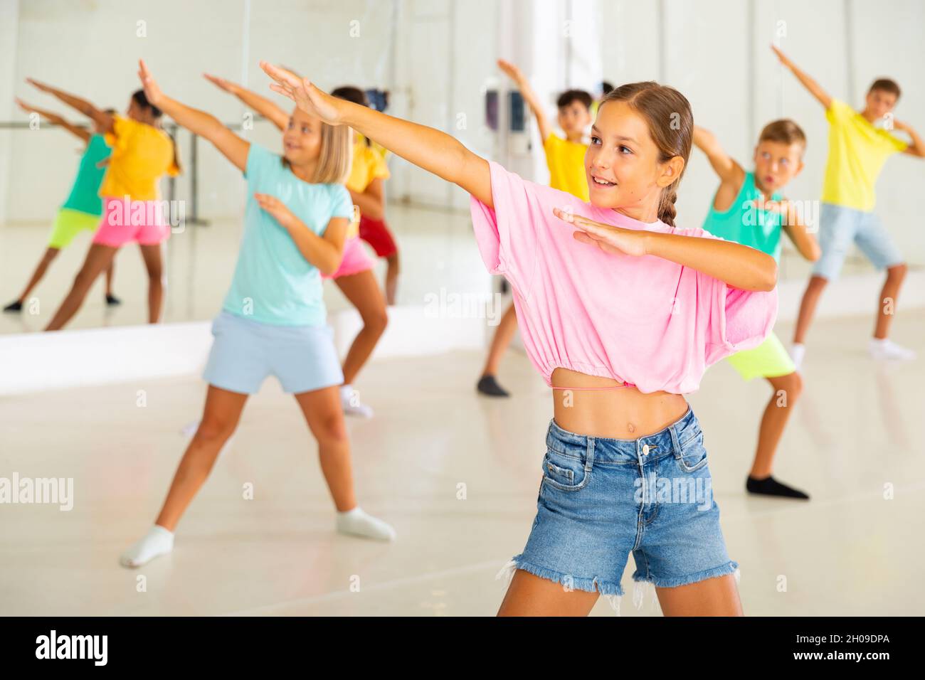 Happy tween girl dancing during group class in choreographic studio ...