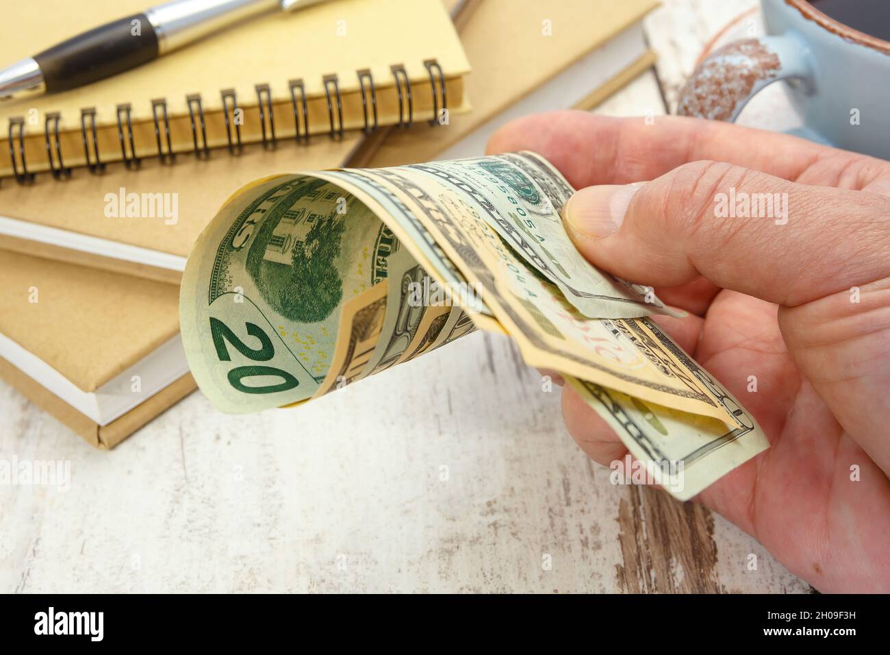 A businessman holds several dollar bills in his hand. Financial concept ...