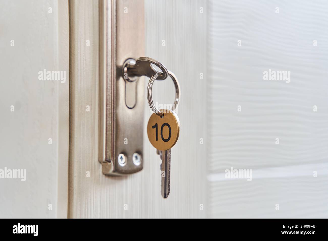 A key with a key fob in the keyhole of the door. Buy a new home concept ...