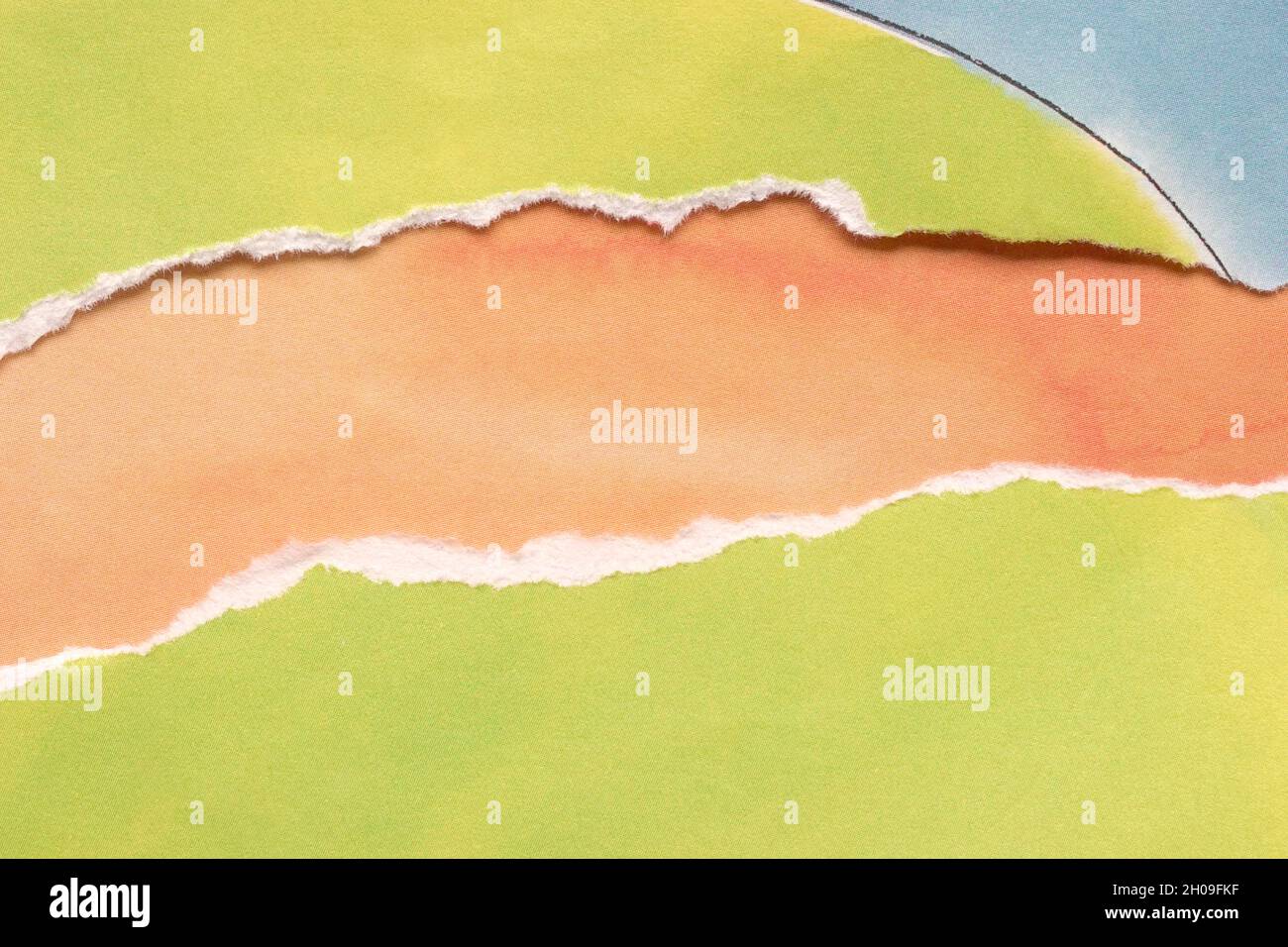 Ripped colored lemon green and blue paper on orange background. Copy ...