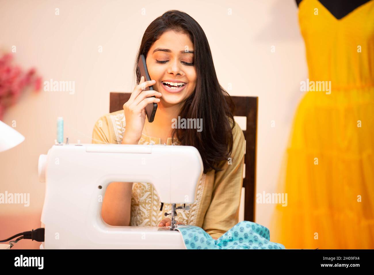 Young indian happy woman,tailor,fashion designer,using sewing machine ...