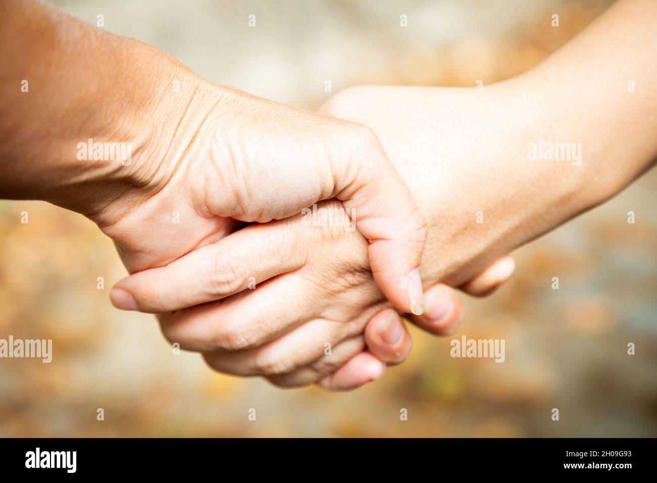 Two women shaking hands outdoors. Team work and agreement setting ...