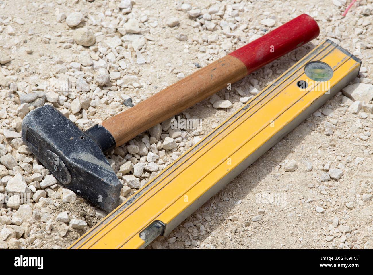 Top view of level tool and hammer on gravel at construction site Stock ...