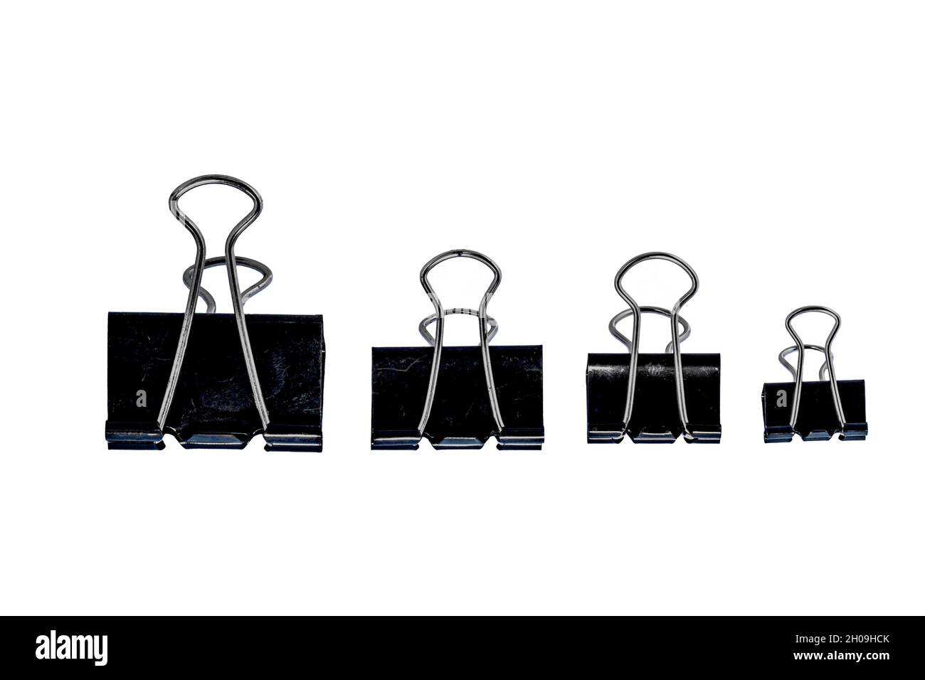 Four black metal paper clips, isolated with a white background, for ...