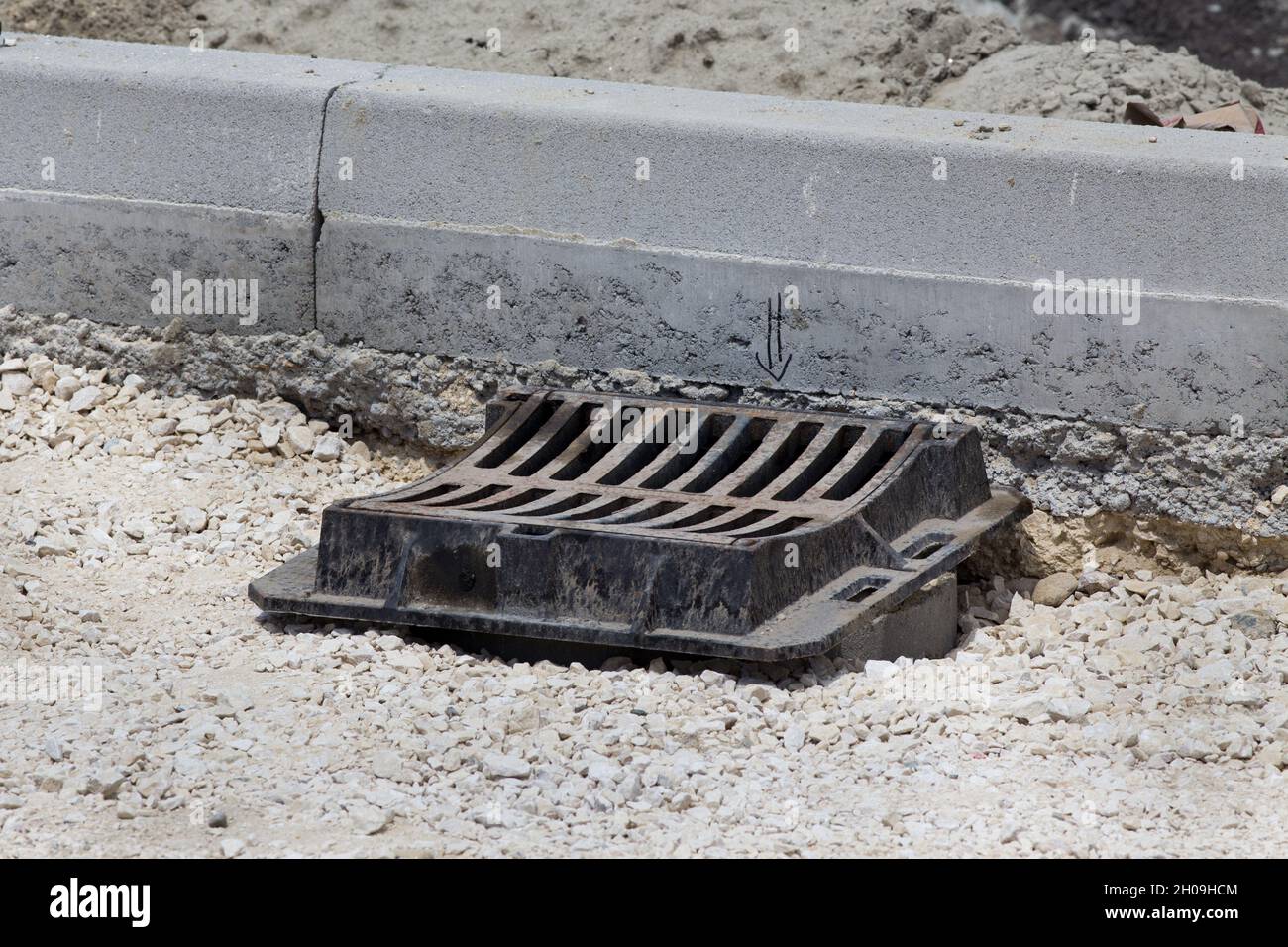 Metal rainwater gutter standing on gravel beside curbs at construction ...