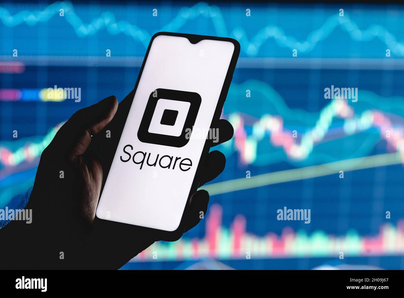 Square logo on smartphone in the hand against the background of the ...