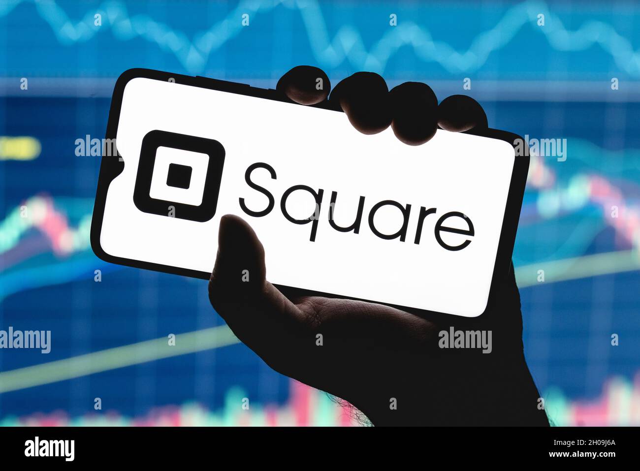 Square logo on smartphone in the hand against the background of the ...