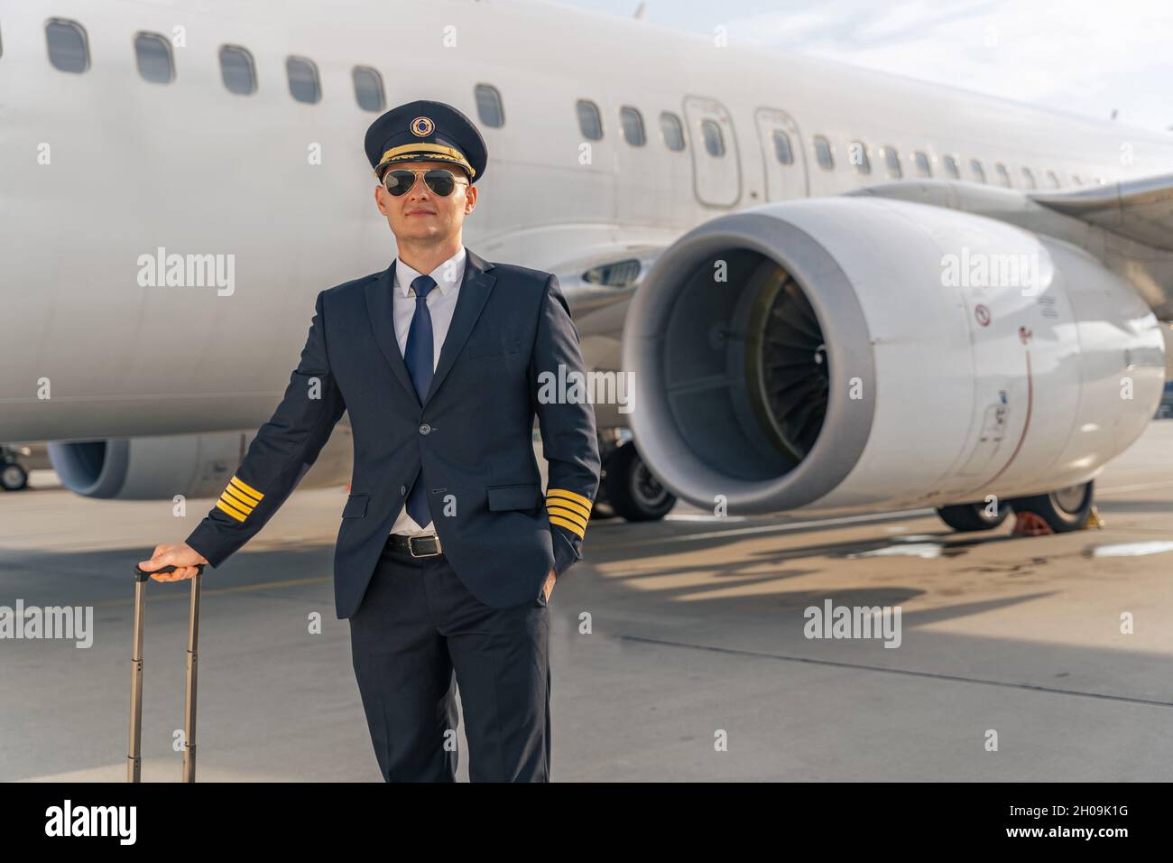 Confident pilot smiling in front of big plane Stock Photo - Alamy