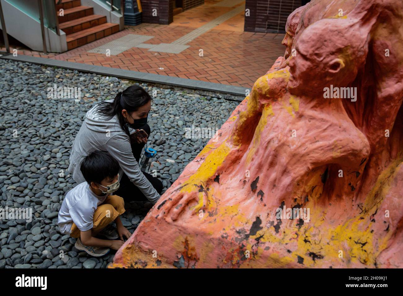 A mother seen introducing words written on the Pillar of Shame to her ...
