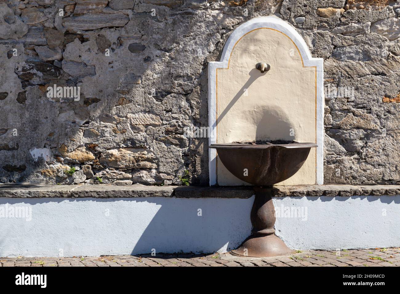 Front view of a fountain with massive ornate metal basin and rough ...