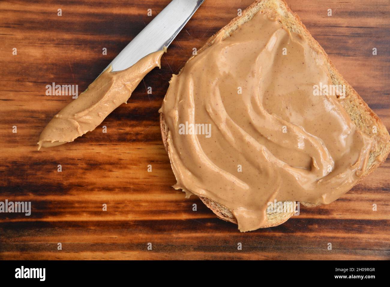 Peanut butter on a slice of bread ona wooden table overhead view Stock ...