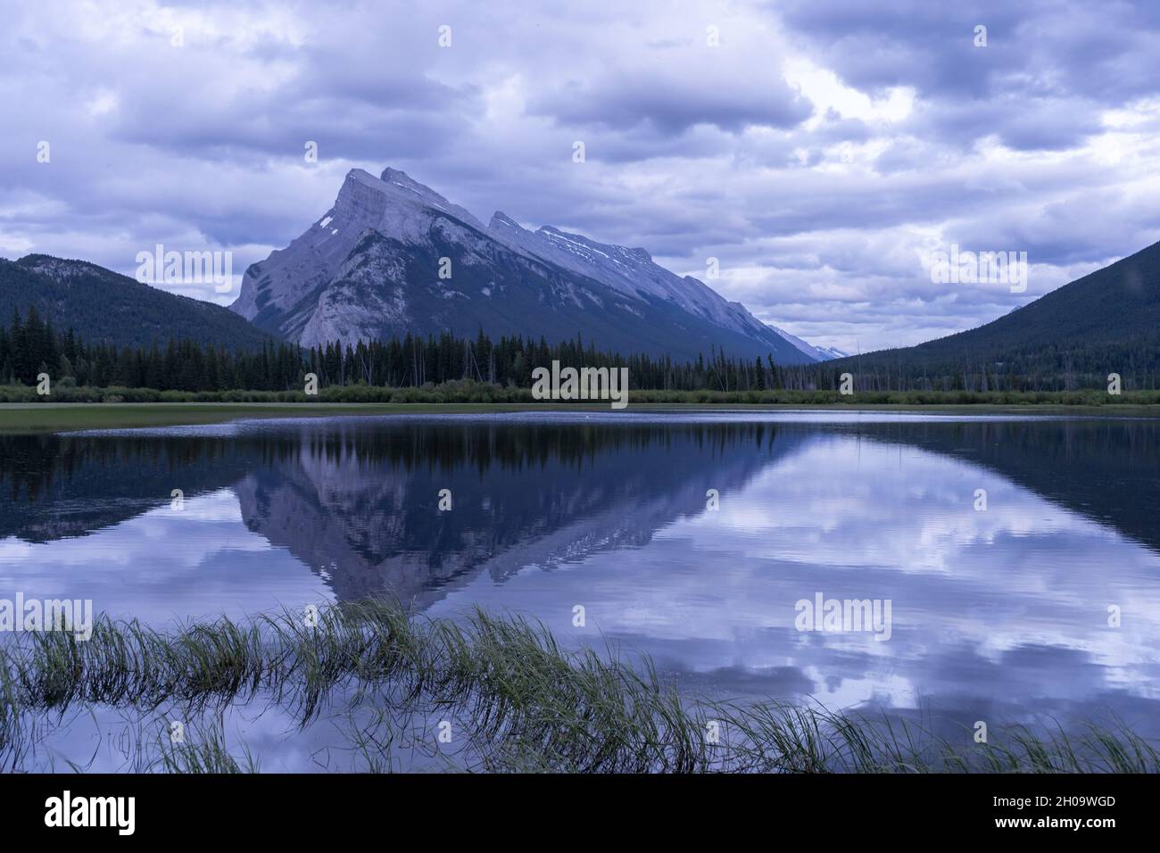 Moody sunset in Canadian Rockies with mountain reflecting on a lake s ...