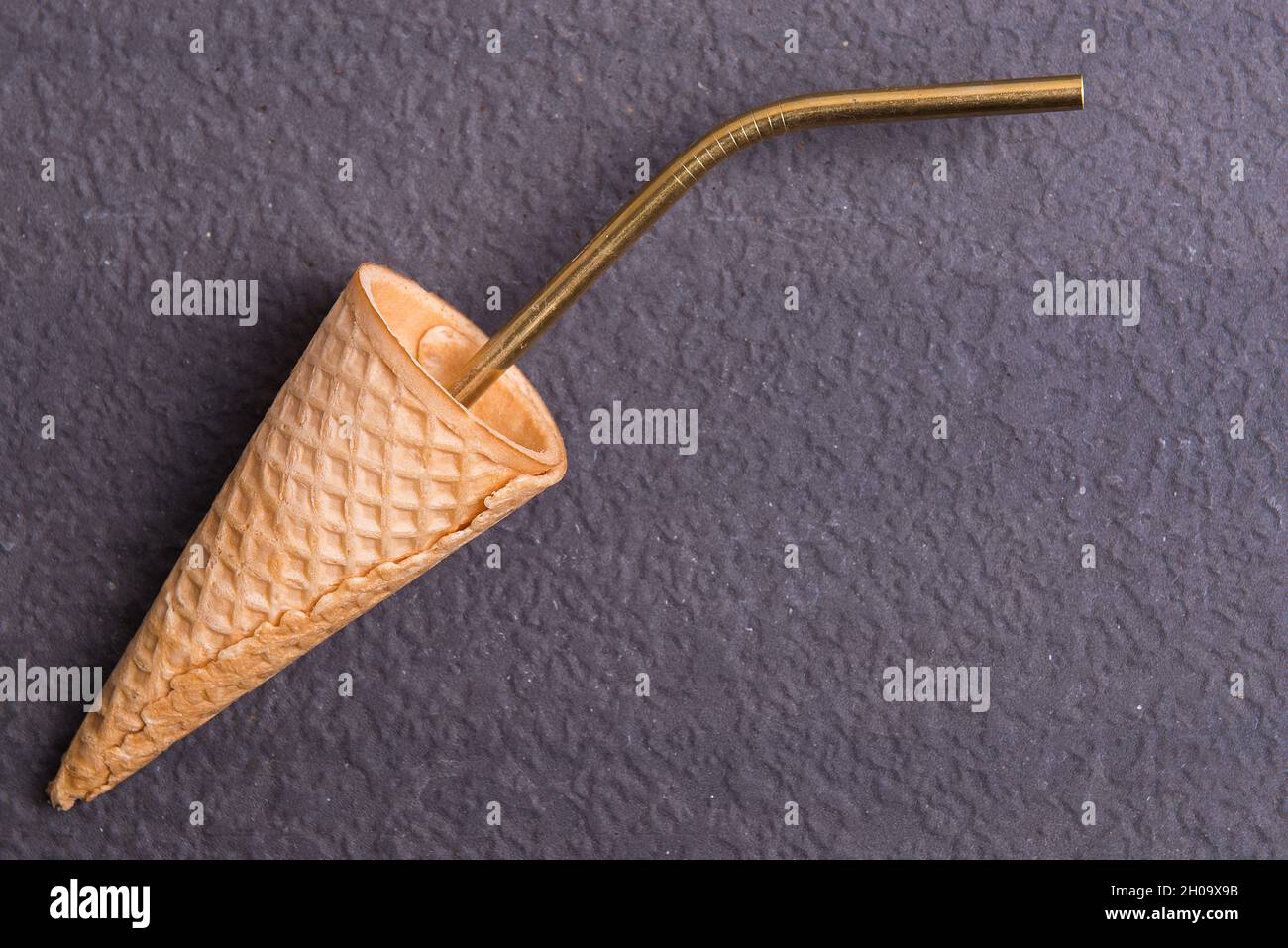 Ice cream cone with straw on black background Stock Photo - Alamy