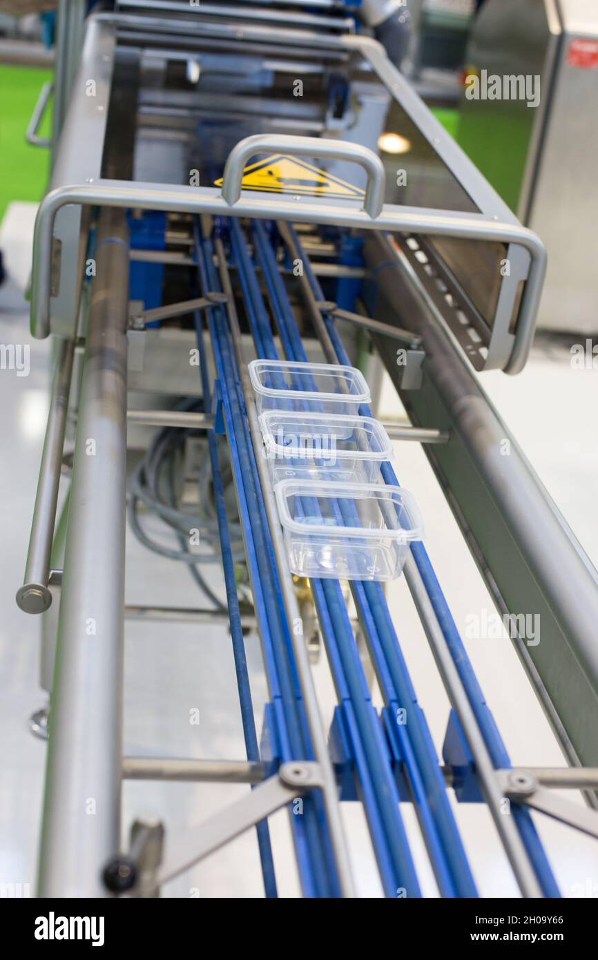 Plastic boxes on conveyor belt of food packaging machine Stock Photo ...