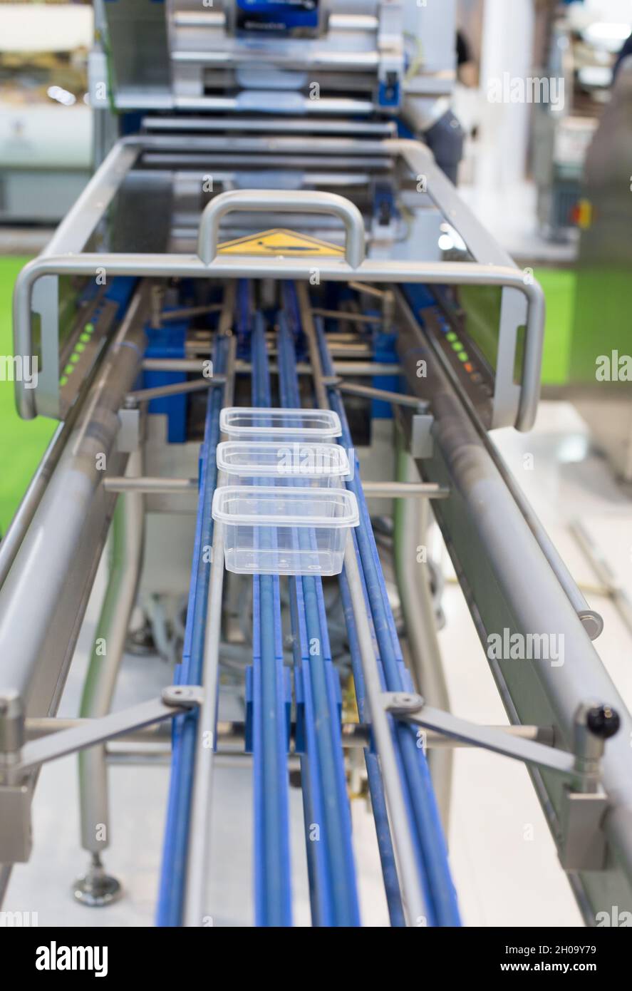 Plastic boxes on conveyor belt of food packaging machine Stock Photo ...