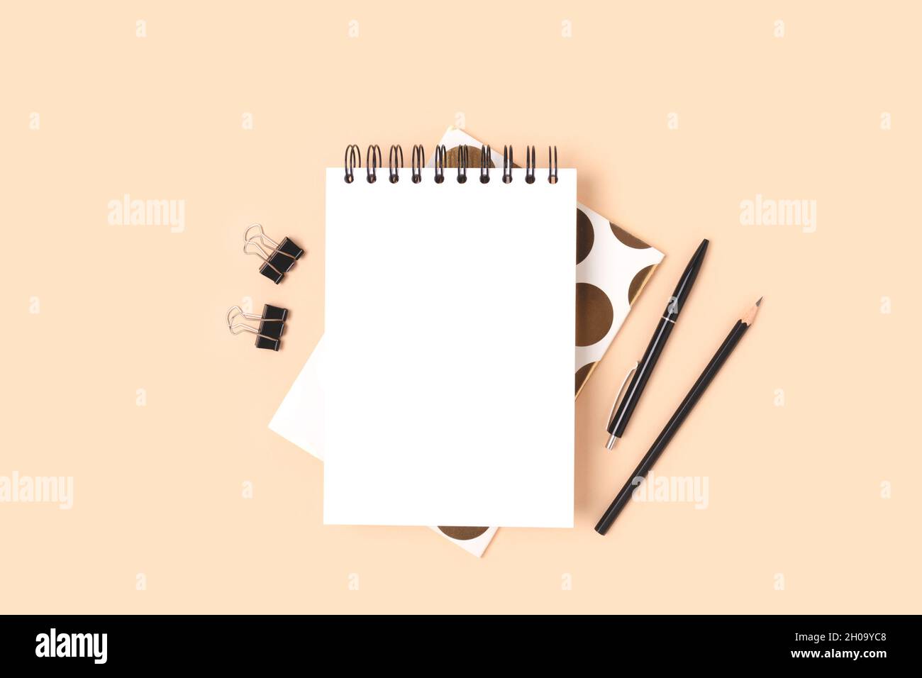 Workspace with empty notepad mockup and stationery on a beige ...