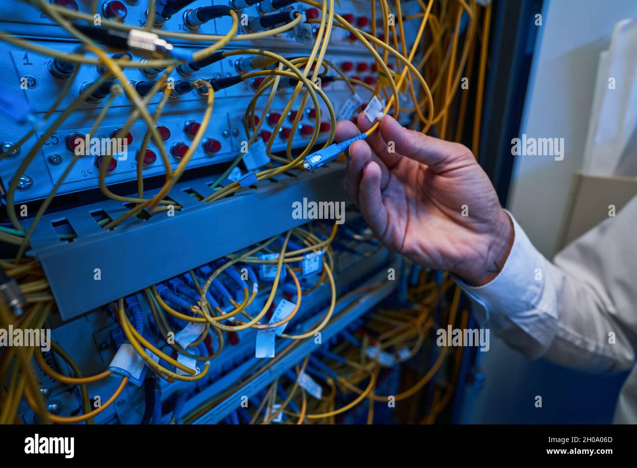 Technician plugging in optical fiber into server rack switch Stock ...
