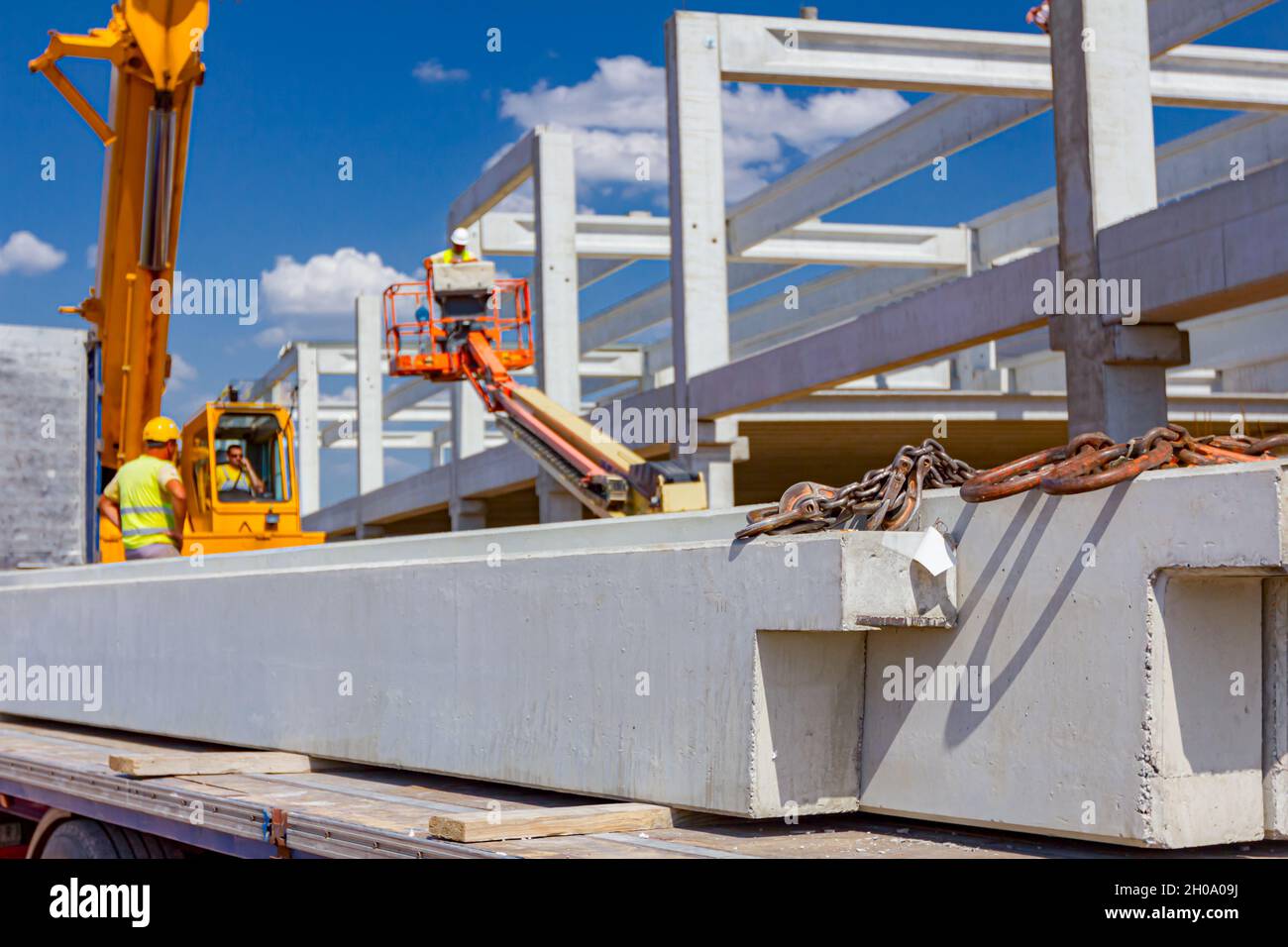 Trailer truck is at unloading cargo, concrete beam for assembling ...