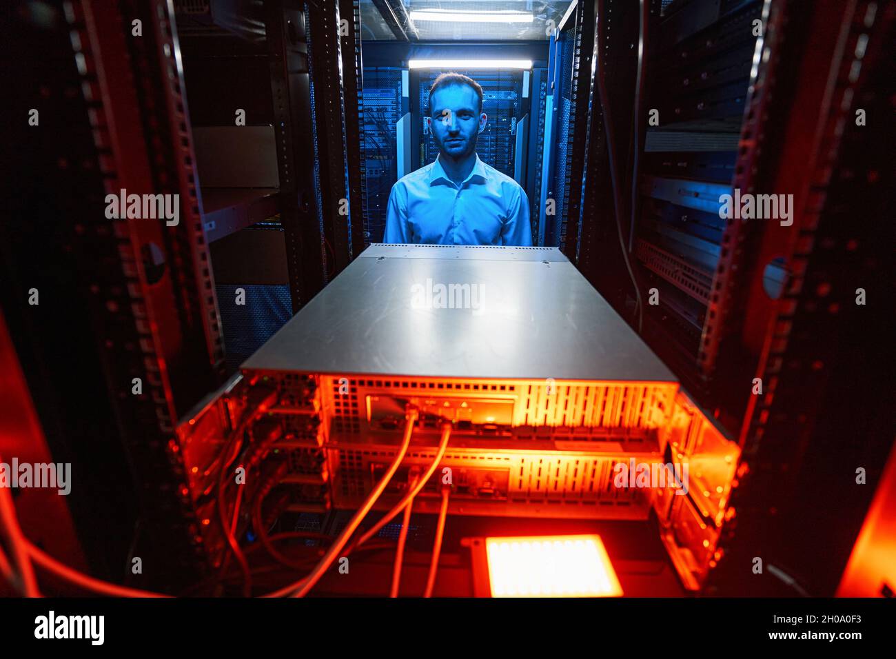 Male server administrator standing before cabinet in data center Stock ...