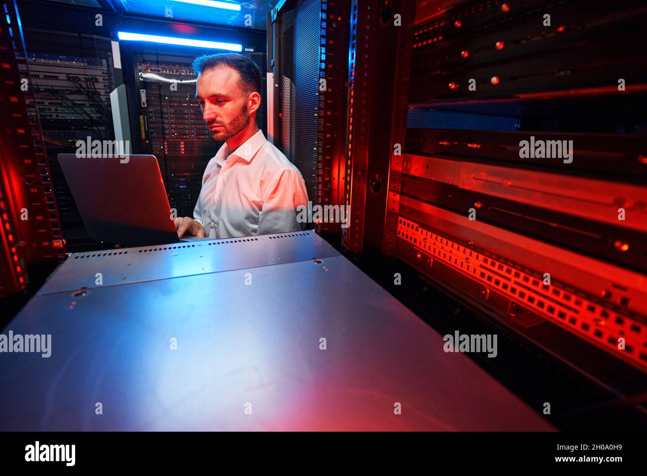 Data center administrator inspecting server rack software Stock Photo ...