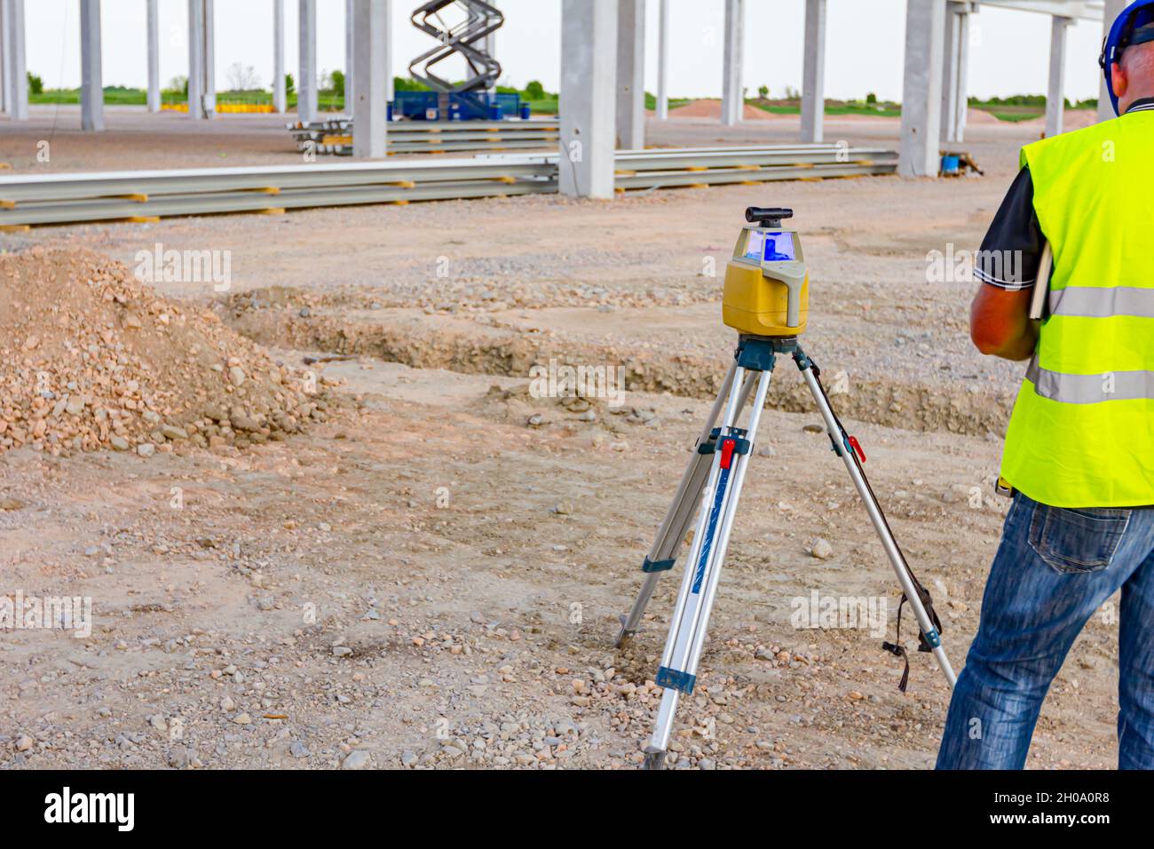 View from behind on construction worker, foreman with safety vest and ...