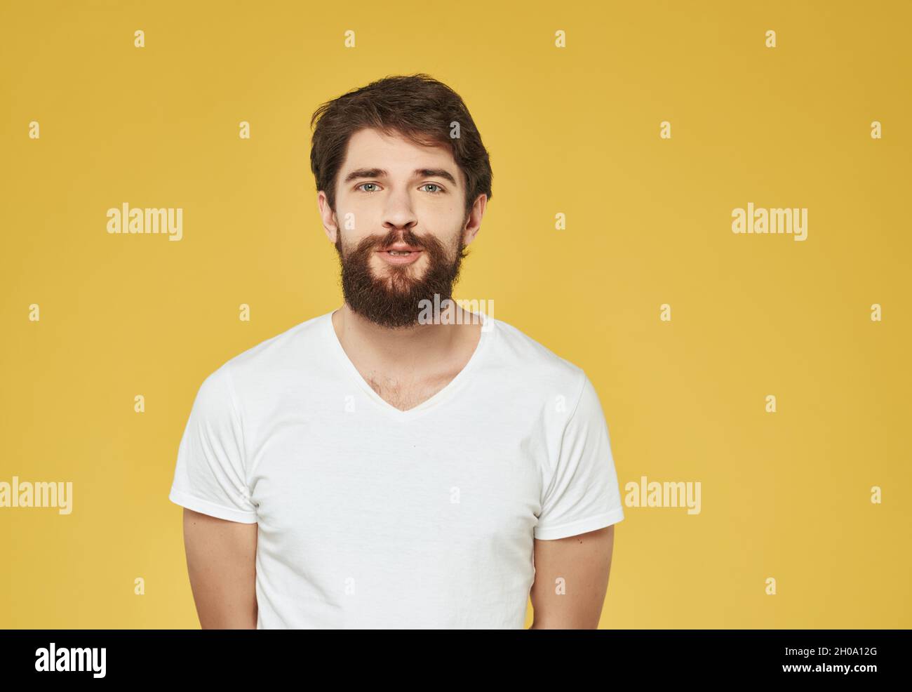 emotional man in a white t-shirt hand gestures anger yellow background ...
