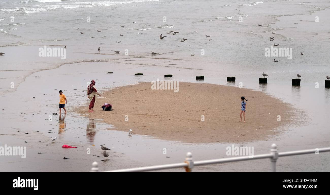Woman and two young children in danger of being cut off by rising tide ...
