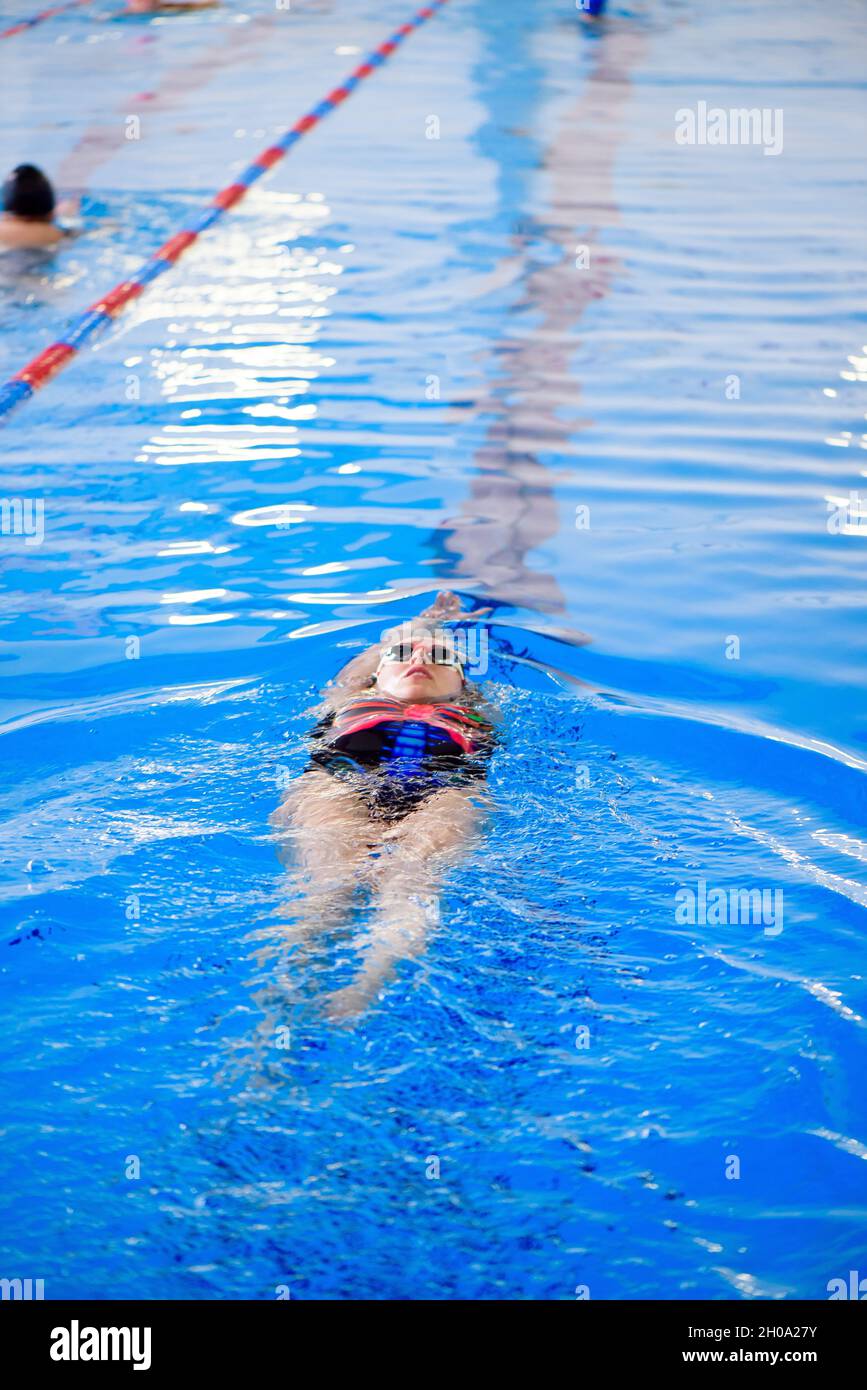 Swimming workout in the sports pool. The coach shows a swimming master ...