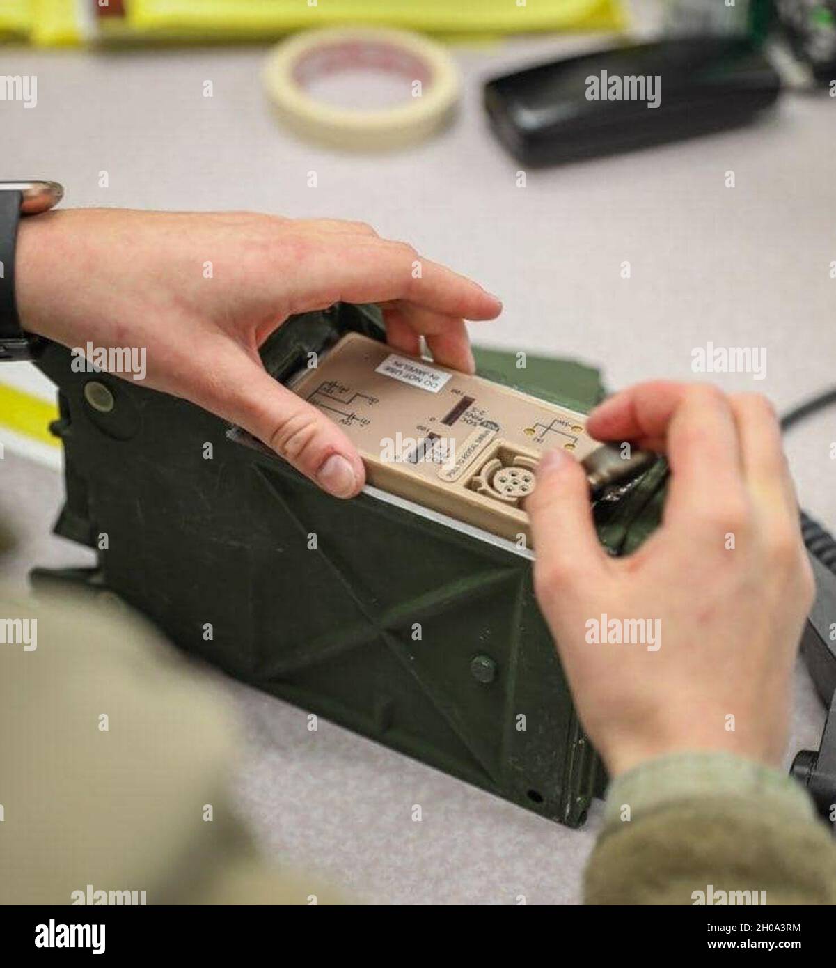 A Soldier with the 103rd Public Affairs Detachment inserts a battery ...