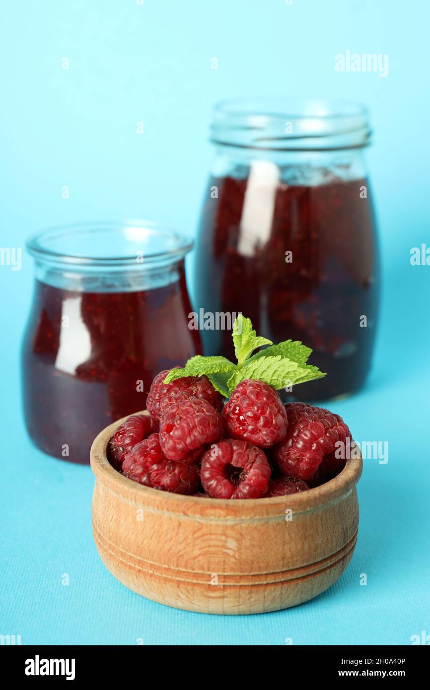 Jars of raspberry jam with ingredients on blue background Stock Photo ...