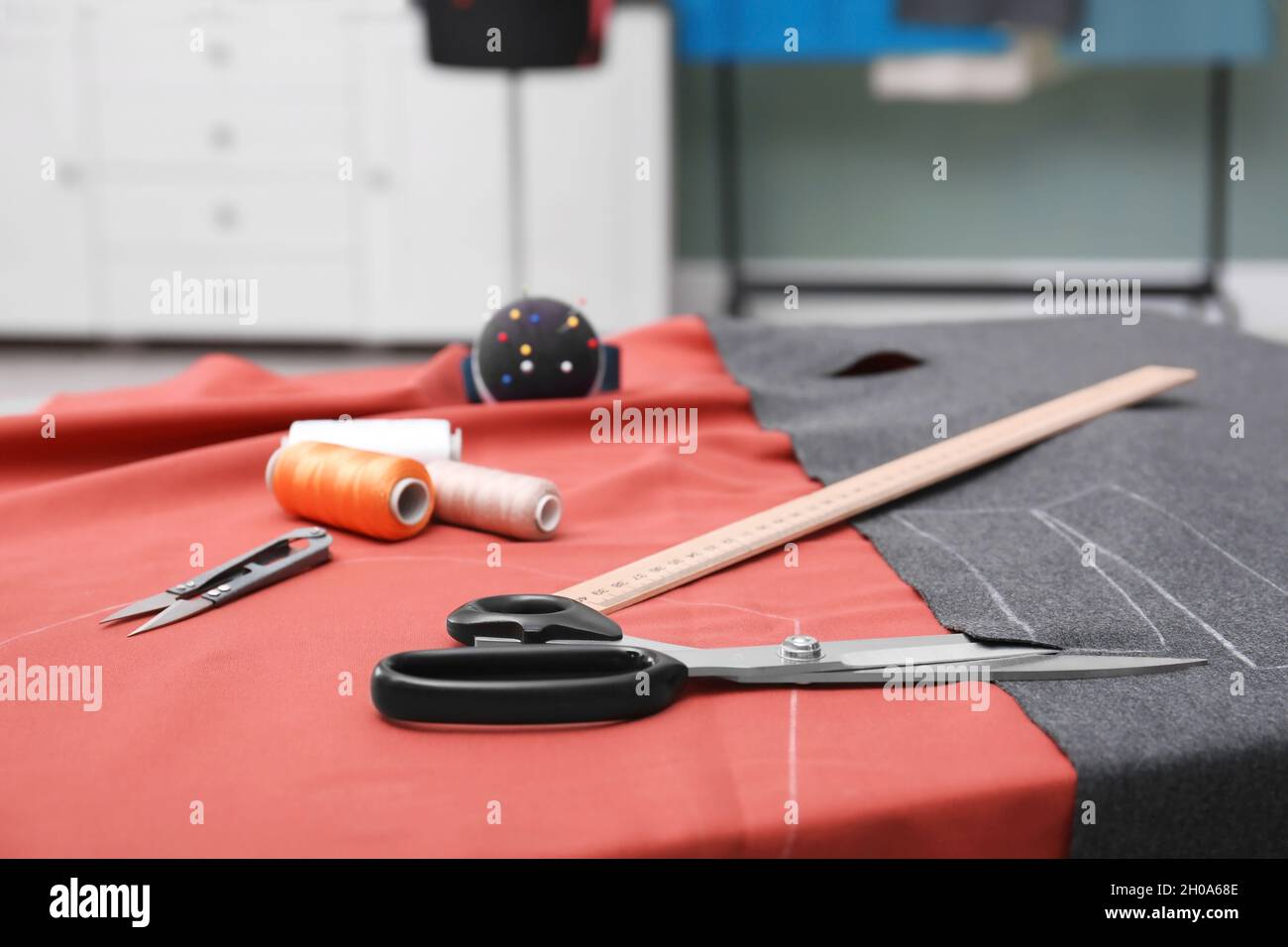 Fabric and sewing tools on table in tailor workshop Stock Photo - Alamy