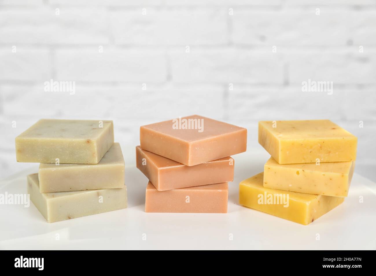 Stacks of handmade soap bars on table against white background Stock ...