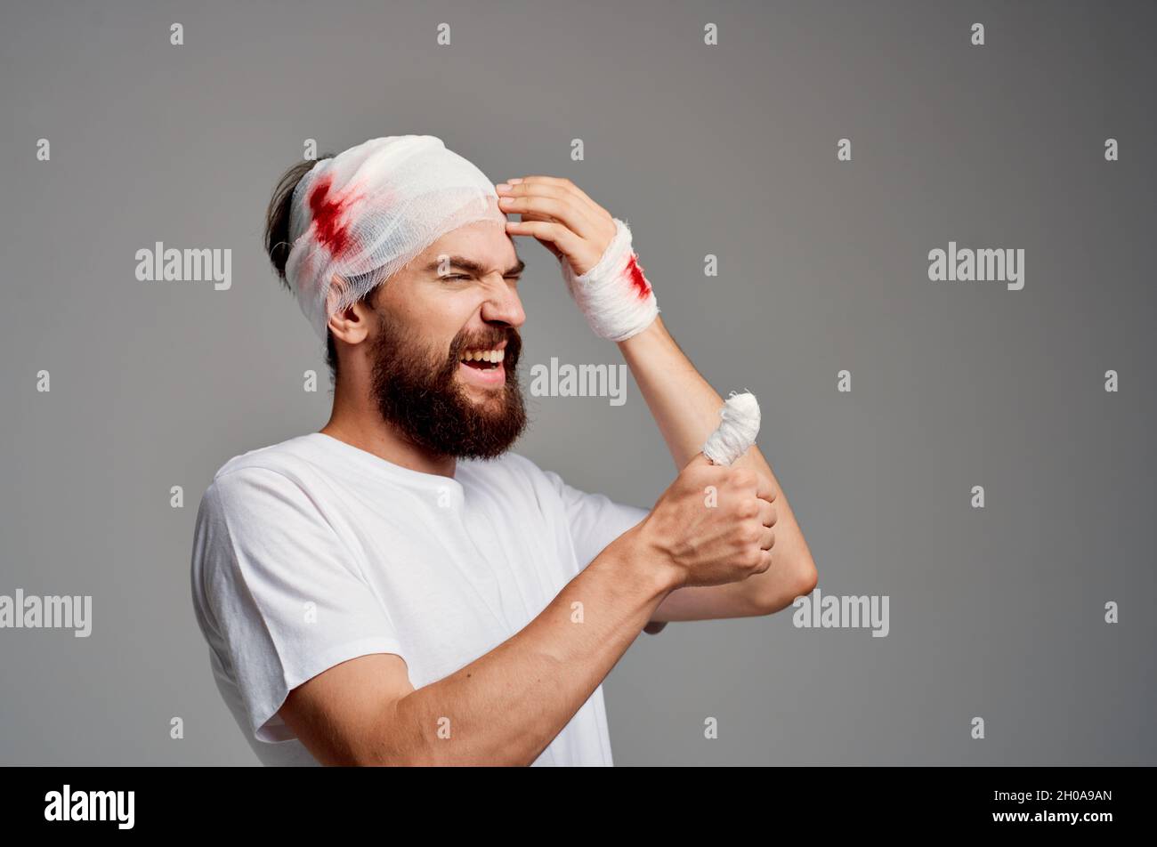 Man bandaged head and hand blood isolated background Stock Photo - Alamy